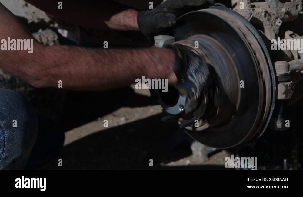 Mechanic works on vehicle wheel and brake assembly B Stock Video ...