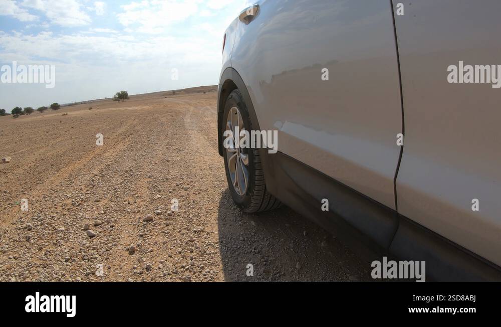 Low angle view of jeep driving through rocky desert in Saudi Arabia ...