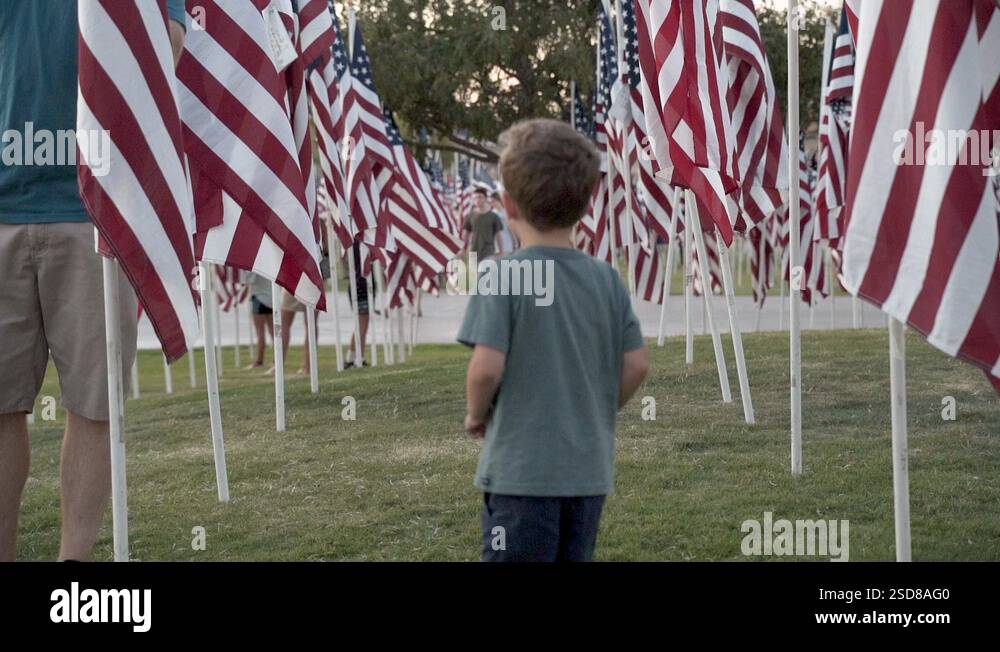 Small Child Boy Waling Slow Motion Through Nine Eleven Flags in a Park ...