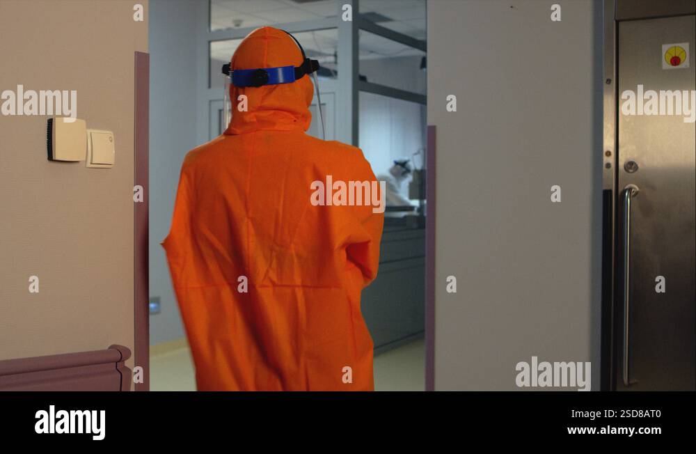 Doctor in Protective Suit Enters Isolation Room with a Sign Reading ...