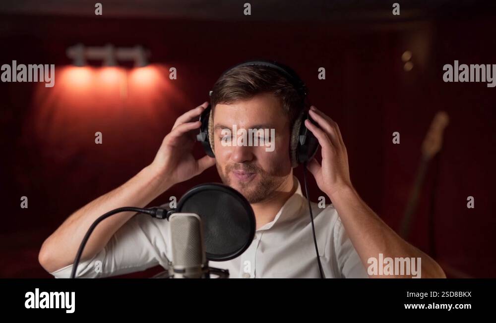 recording studio man puts on his headphones and starts talking into the ...