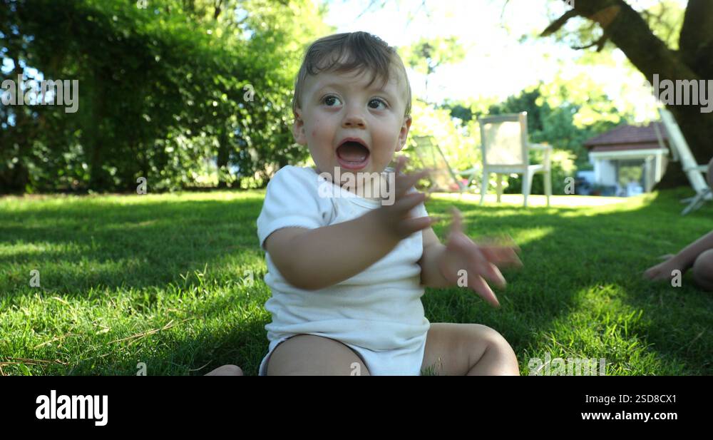 Happy baby clapping hands in outdoor garden, joyful handsome toddler ...