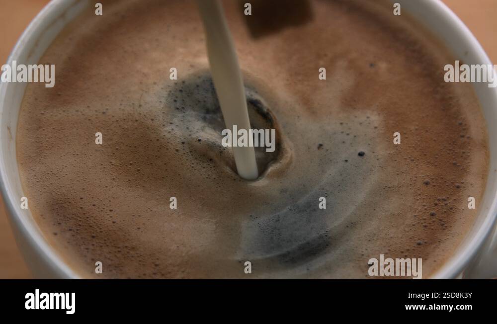 Milk is Pouring into a Coffee Cup with Brown Sugar Tossed Stock Video ...