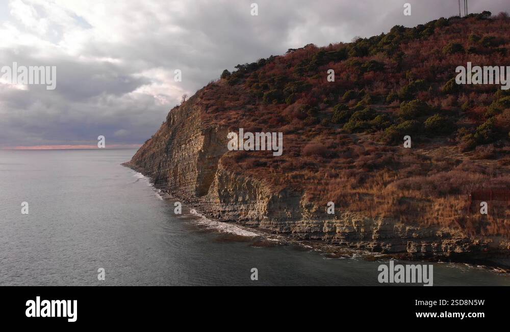 Sedimentary rock on a sea shore. Sunset light on laminated cliff and ...