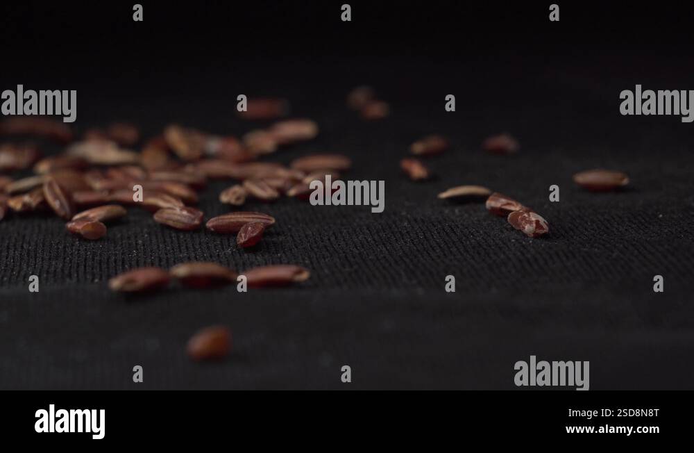 Brown rice falls beautifully on spinning black table. Brown rice is ...