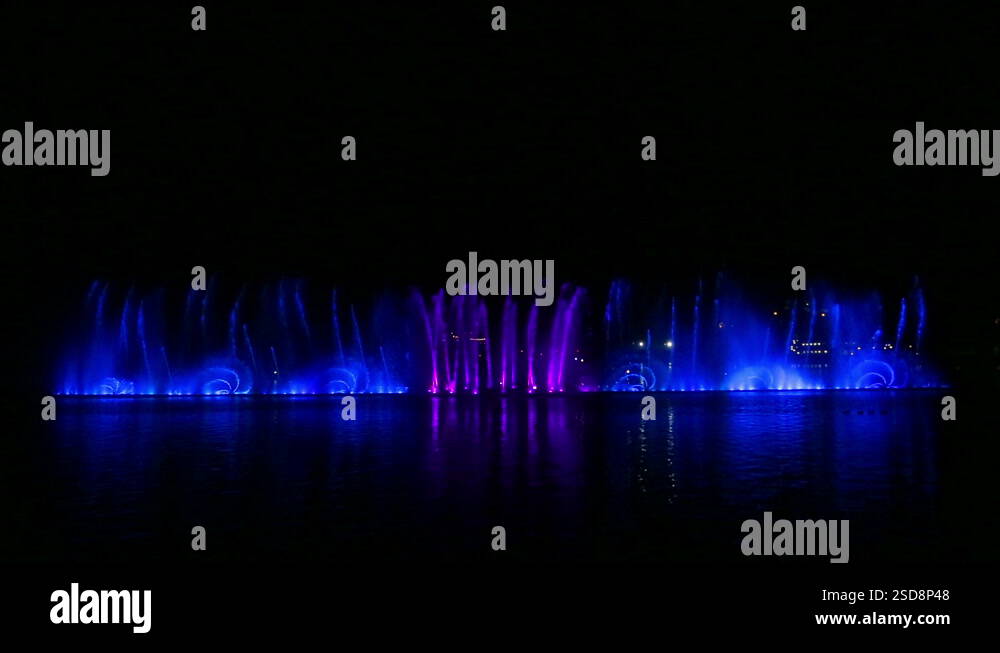 The night show of fountains multi-colored on water reflected in water ...