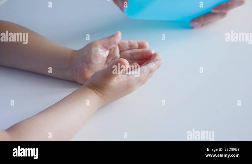 mom pours liquid soap on the palm of the child during the epidemic ...