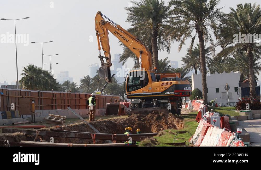 A crane digging the ground and collecting soil on a dumping truck ...