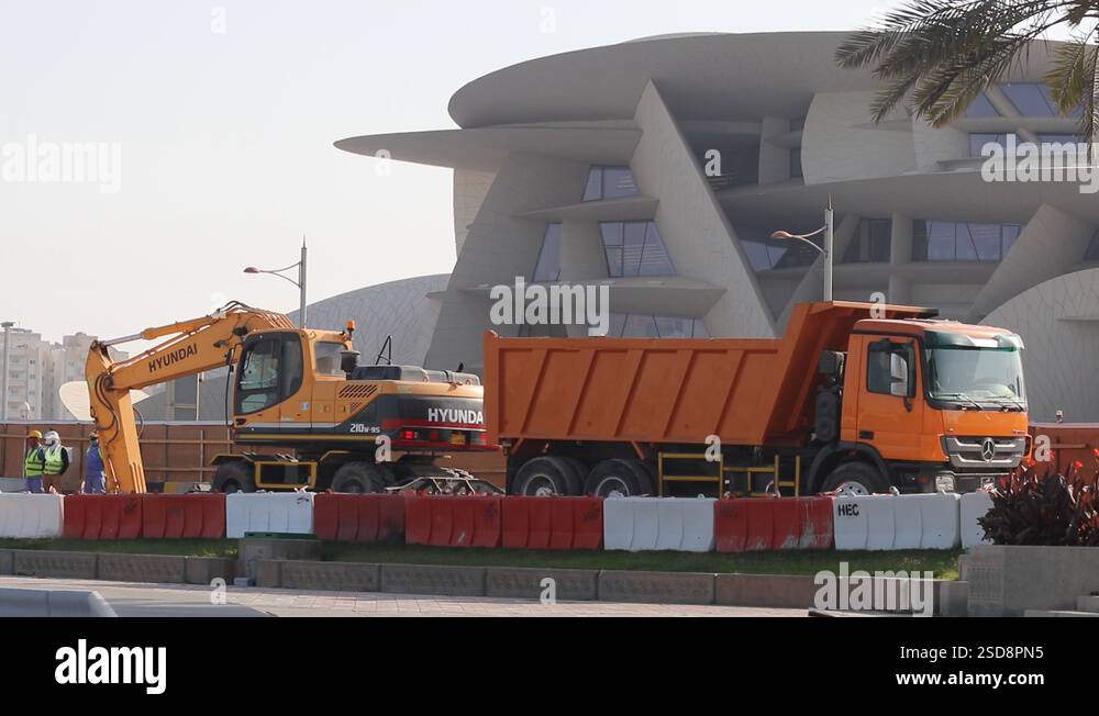 A crane digging the ground and collecting soil on a dumping truck ...