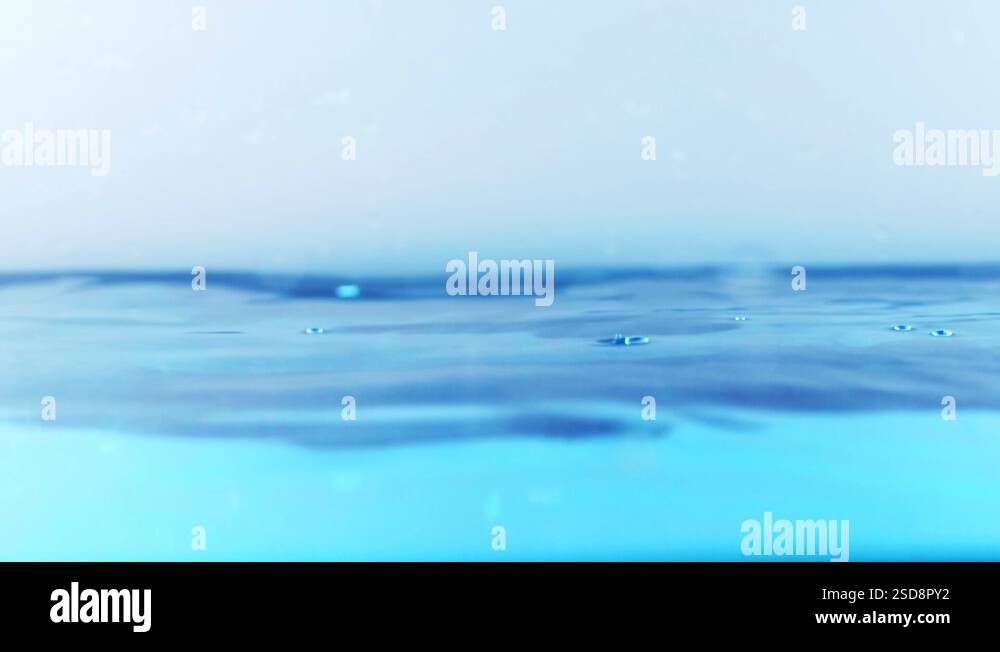 The clean water surface in slow motion fills the screen with water ...