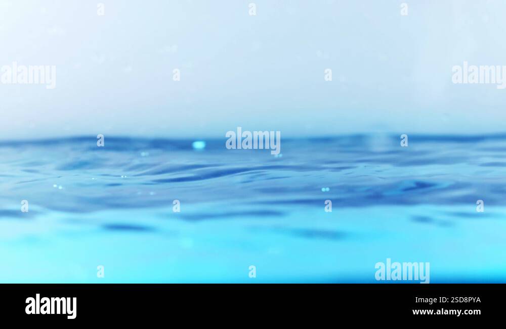 The clean water surface in slow motion fills the screen with water ...