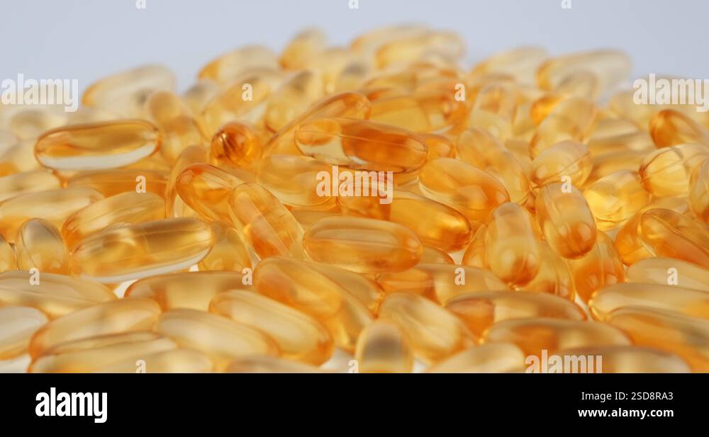 Close-up of omega 3 bright orange gel capsules rotate on white ...