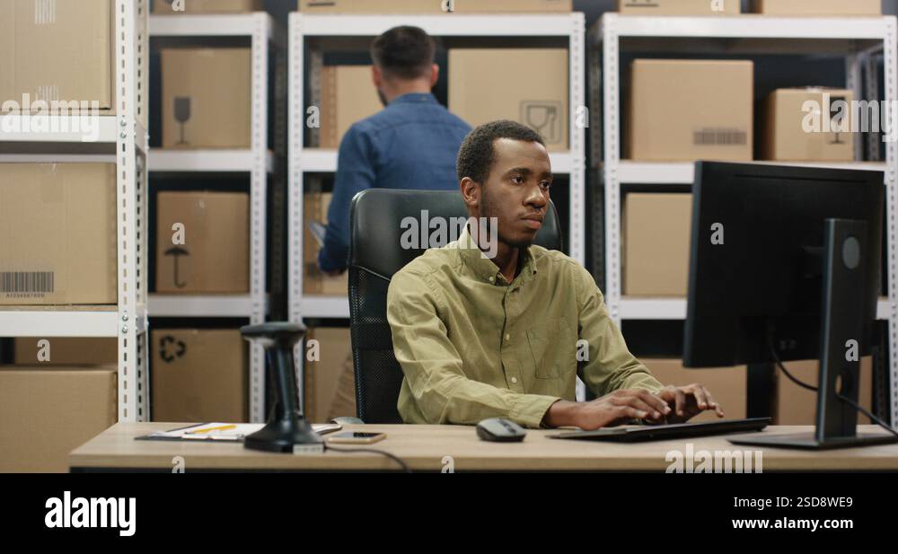 Young attractive African American postman sitting at desk in post ...