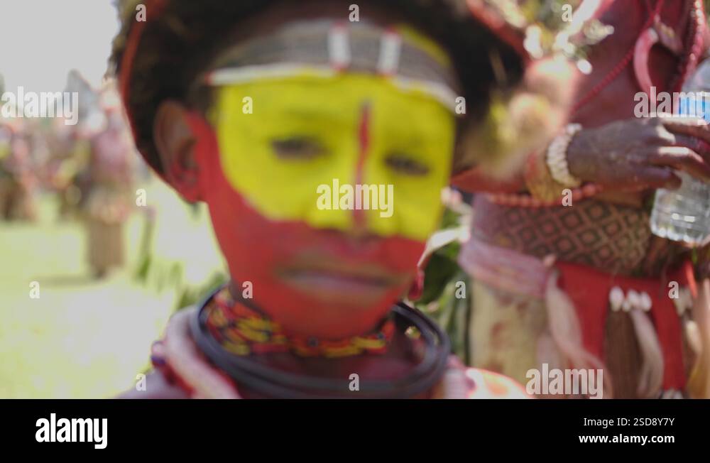 Extreme close up Rack focus shot, tribal boys face covered in red and ...