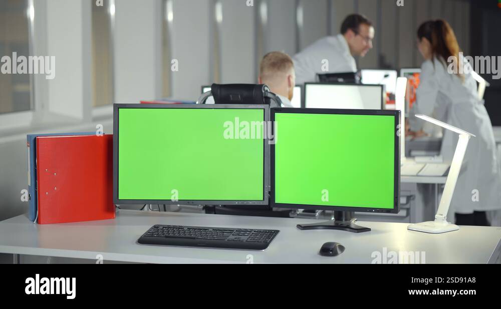 Computer monitors on desktop with green screen in engineering lab Stock ...