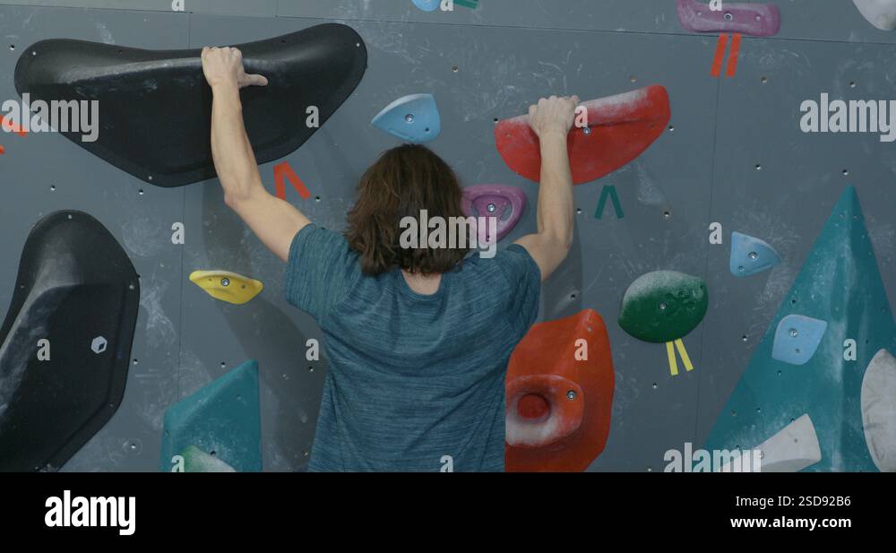 Man climbs the wall, climber training on a climbing wall, practicing ...