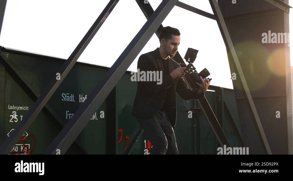 Young Filmmaker film handheld the sunset. Industrial Stock Video ...