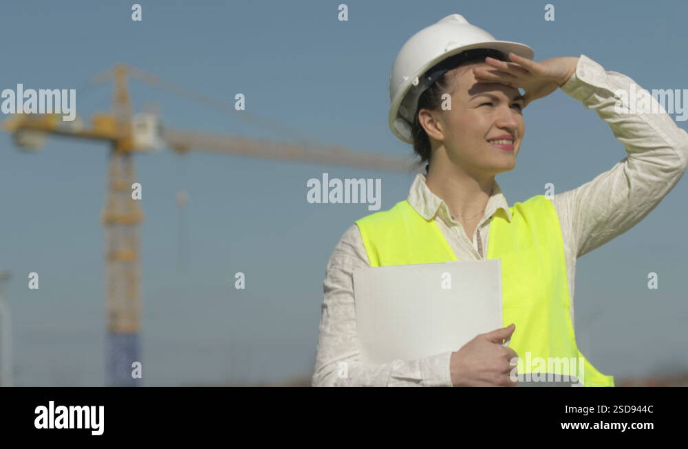 Woman builder in protective clothing made his a visor with the hand and ...