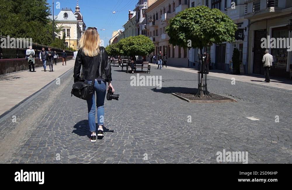 The girl walks with the camera in the hands of the ancient city Stock ...