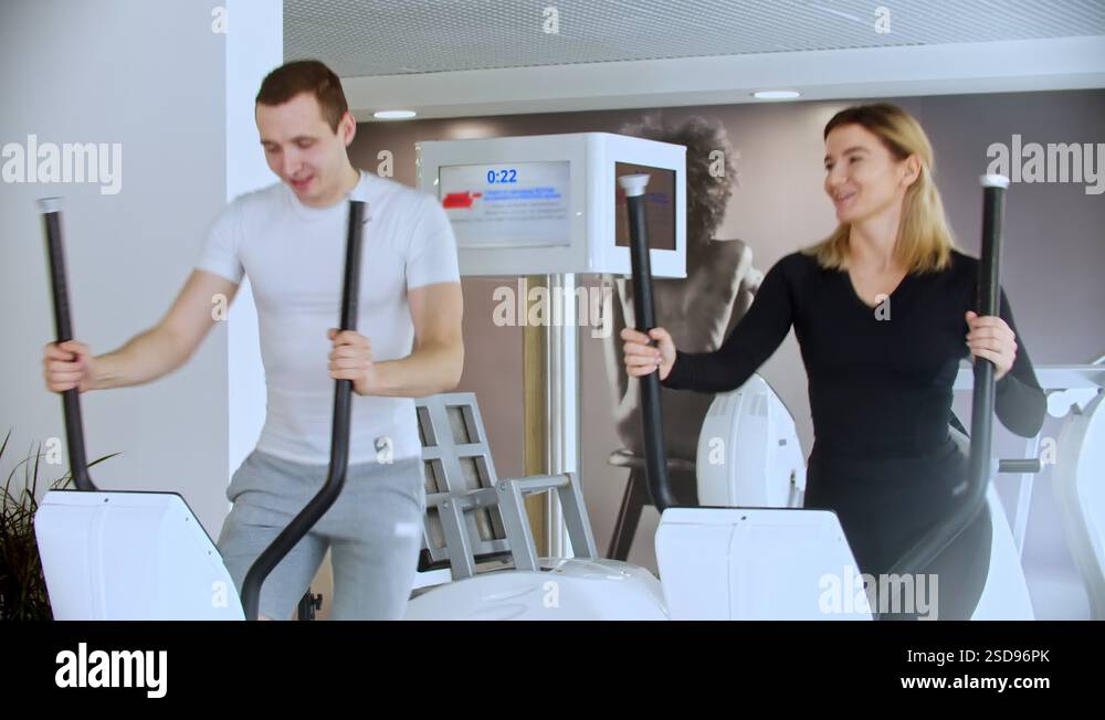 Modern gym - sportsman and sportswoman doing morning exercises in the ...
