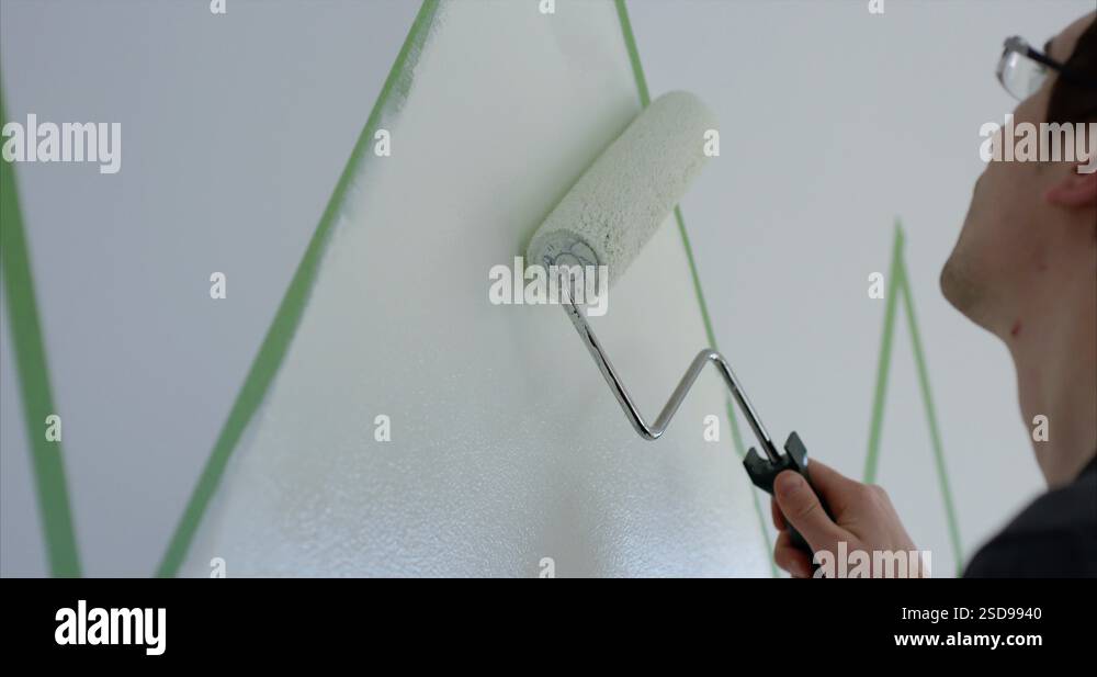 Man painting lines on walls with paint roller - focusing on painting within t Stock Video ...