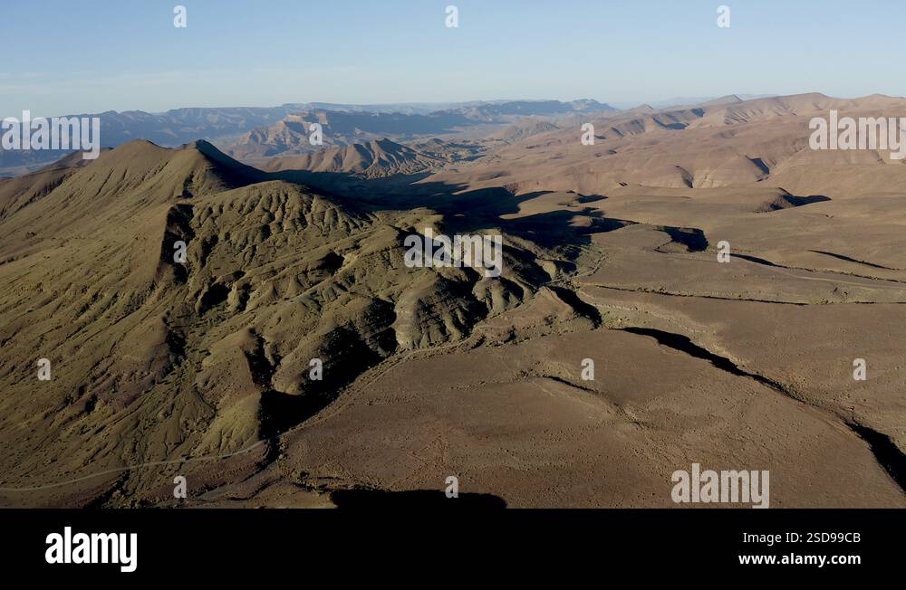 An aerial of deep fissures and gorges cutting through sand dunes and ...