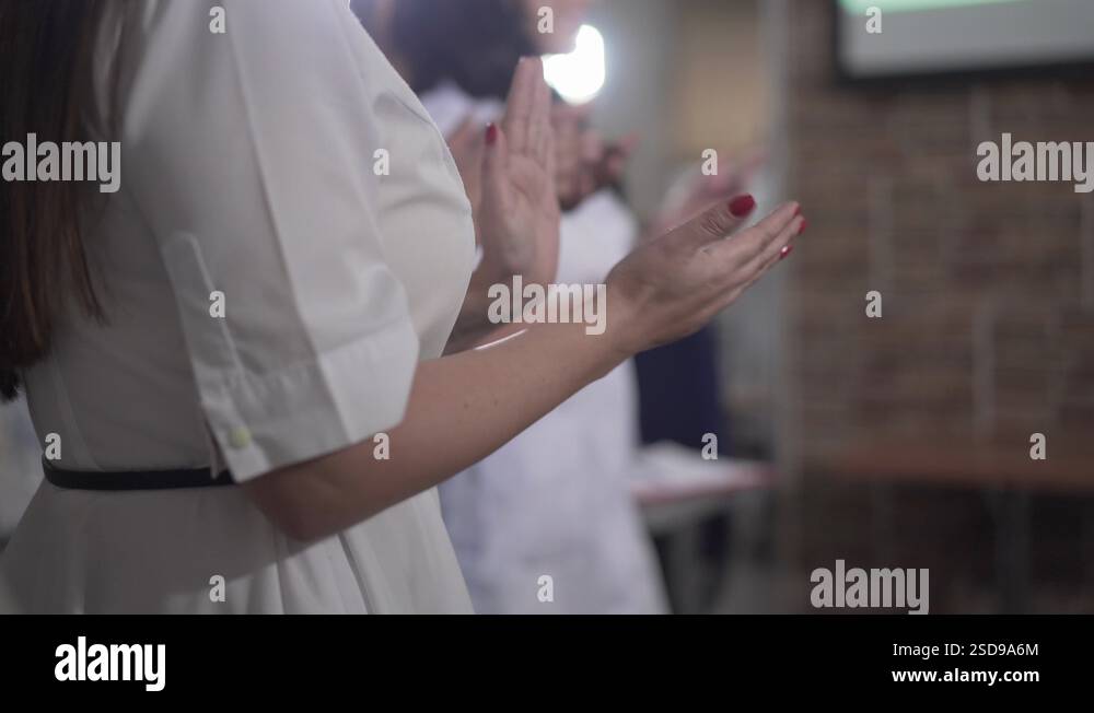Side view of unrecognizable medical workers in white uniform clapping ...