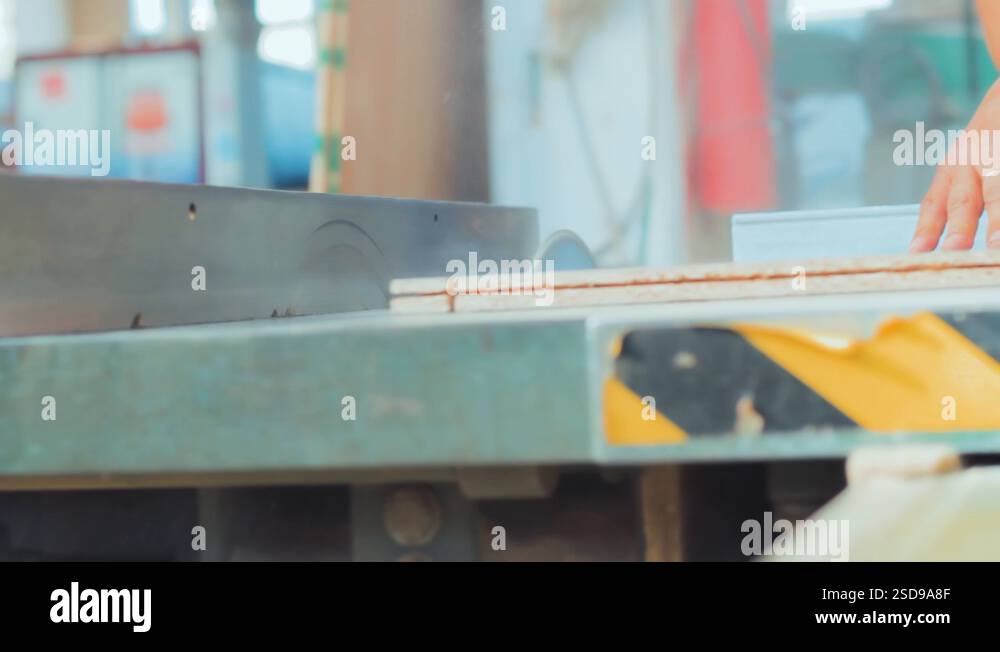 Worker pushing plank of wood through a table saw Stock Video Footage ...