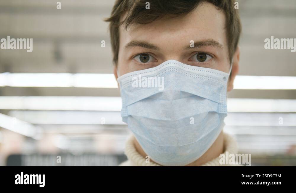 man takes off mask looking at camera in supermarket close-up, stop ...