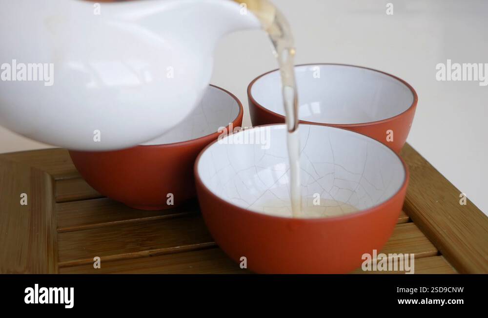 Tea master pours fermented green tea into tea cups. Element of ...