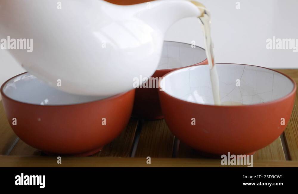 Tea master pours fermented green tea into tea cups. Element of ...