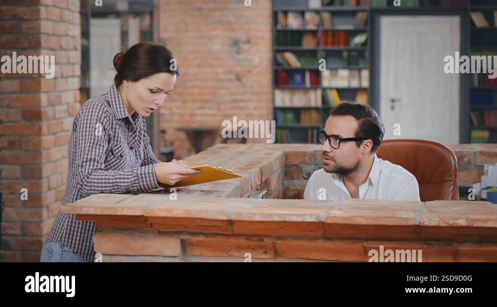 Employee consulting reader in library at counter desk Stock Video ...