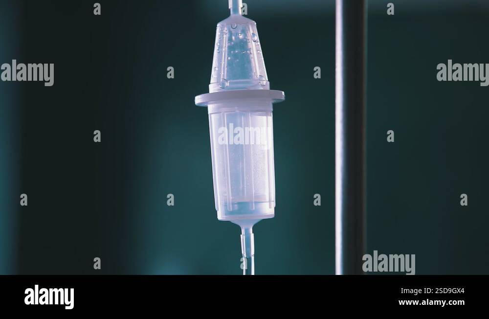 Drops of healthy liquid dripping quickly in a blue plastic dripper in a ...