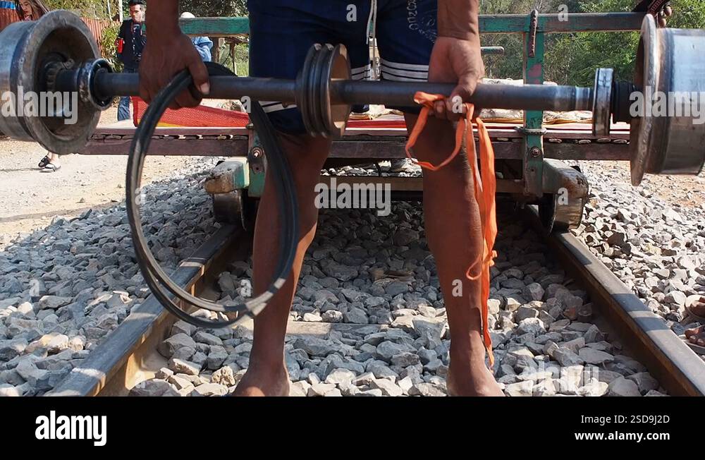 A Man Lifting The Steel Wheel Of A Battambang Bamboo Train From The ...