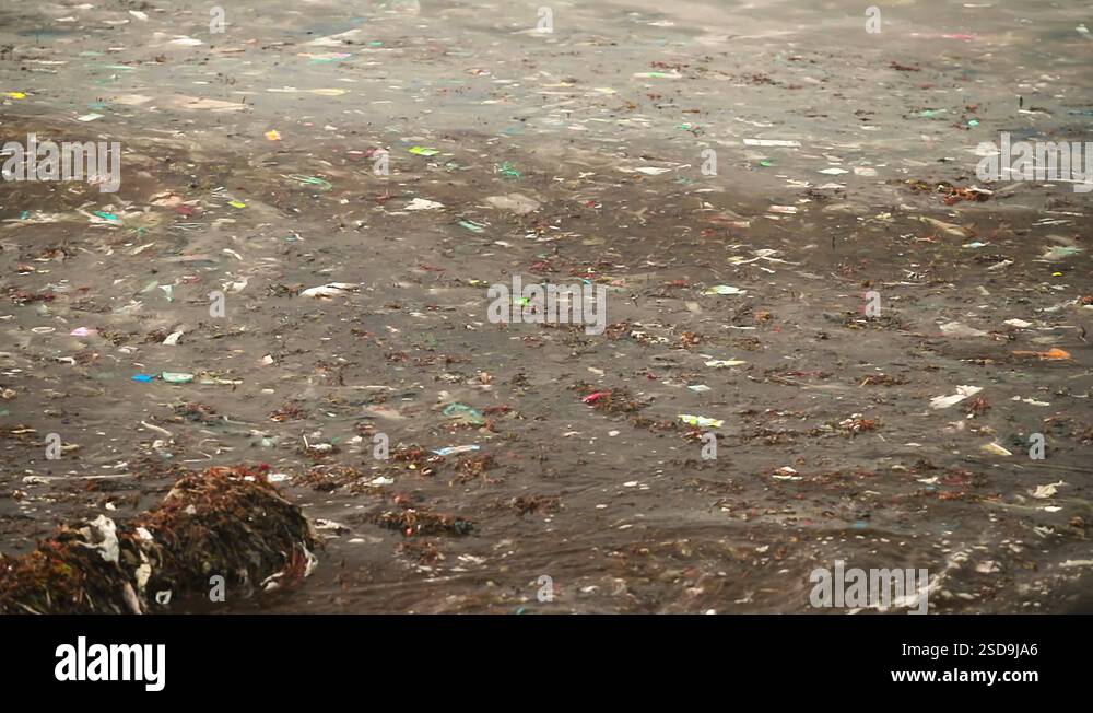 Sea waves full of litter hitting the beach. Huge dump in tropical ...