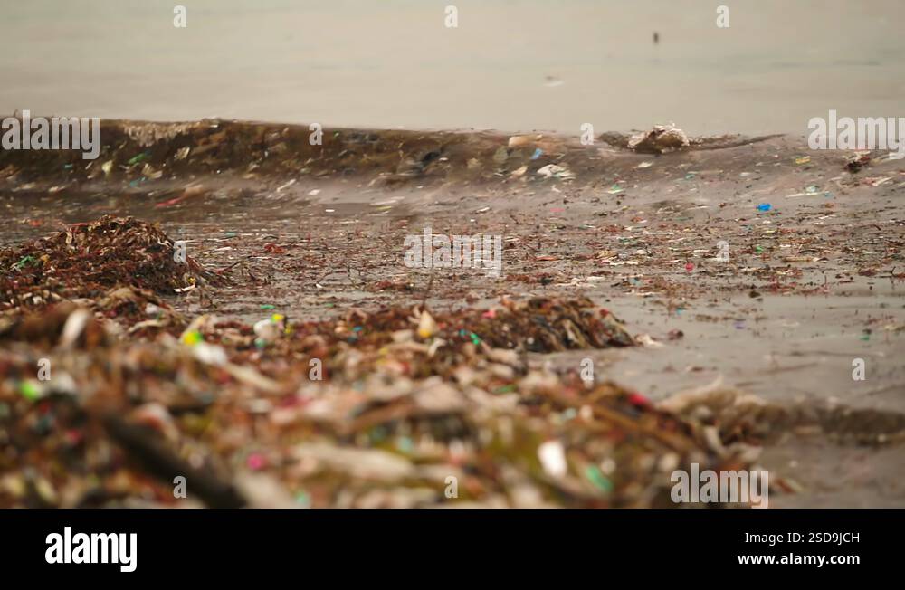 Sea waves full of litter hitting the beach. Huge dump in tropical ...