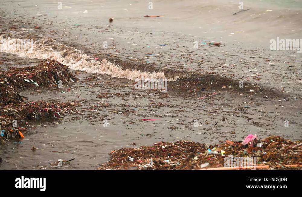 Sea waves full of litter hitting the beach. Huge dump in tropical ...