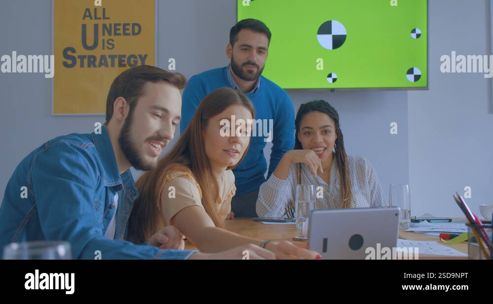 Young colleagues in sunny office use tablet computer online call ...