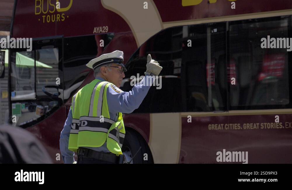 Old NYPD traffic officer directing traffic in Downtown Manhattan on a ...