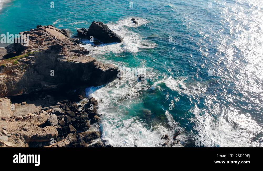 Blue sea beating against rocky coastline Stock Video Footage - Alamy