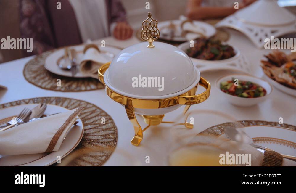 Arab man opening white luxury chafing dish with soup on dining table ...