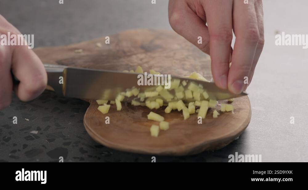 Slow motion man hands chopping fresh ginger root with knife on olive ...