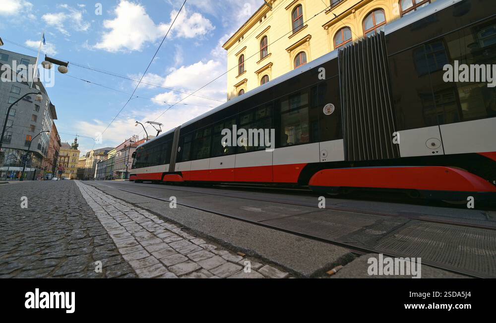 LOW ANGLE, ground level shot as a tram pulls away from a tram stop and ...
