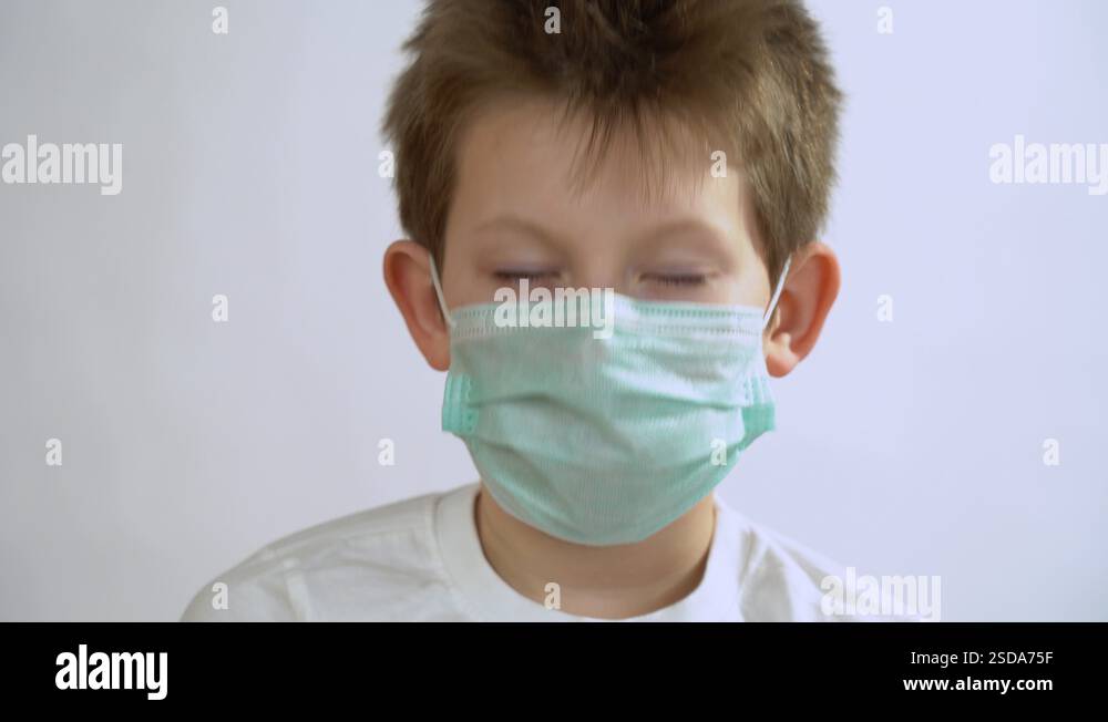 Caucasian male with blue eyes in medical mask nods his head up and down ...