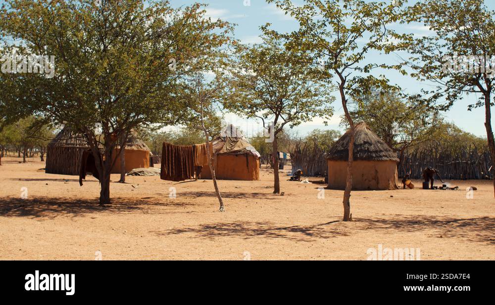 Himba tribe village with people walking around, sunny day, Namibia, 4k ...