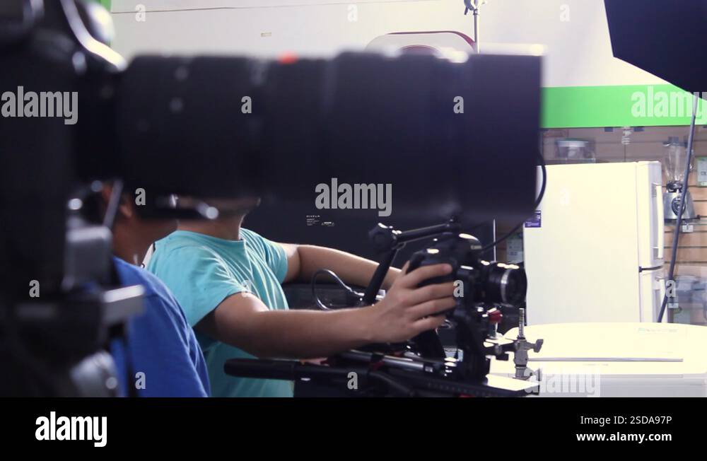 Rack focus from lens to a cameraman in a film production set Stock ...