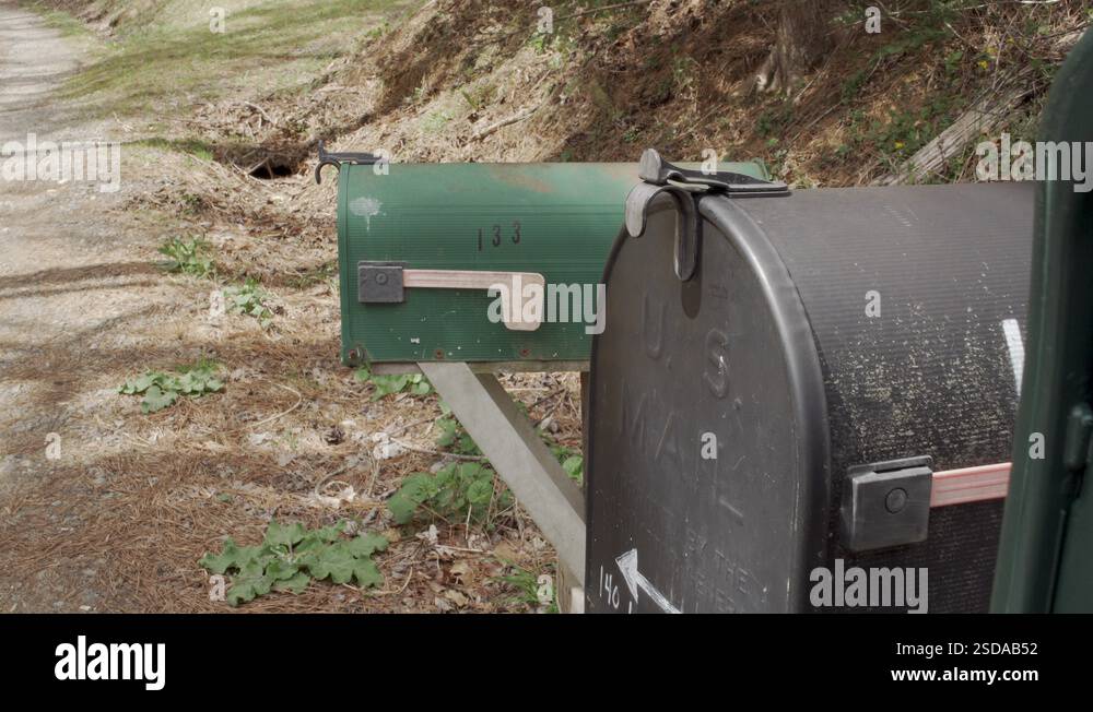 Man wearing a face mask and gloves getting his mail out of a mailbox ...