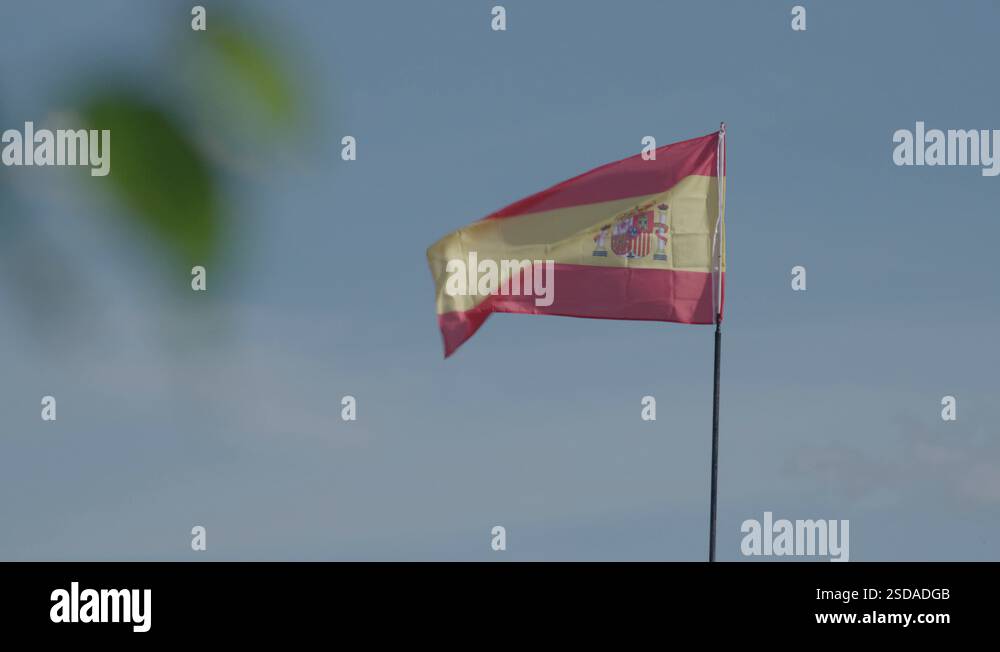 Spanish flag waving in the breeze on a brigt sunny day against a blue ...