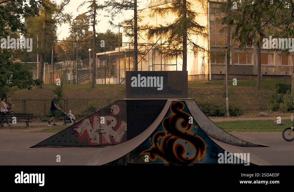 Slow motion backflip on bmx at the skatepark. Young guy jumping upsite ...