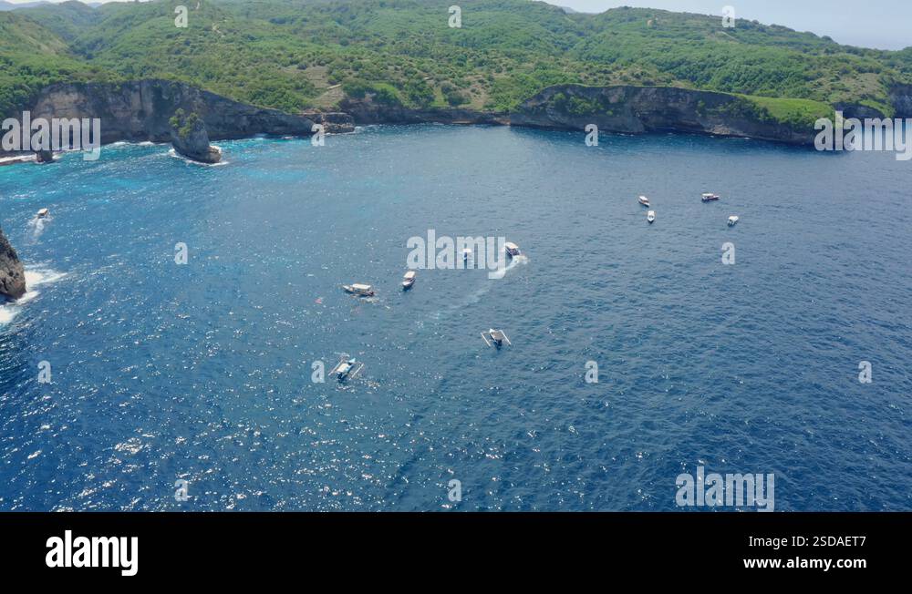 Aerial view of boats floating in azure ocean in bay of island, Nusa ...